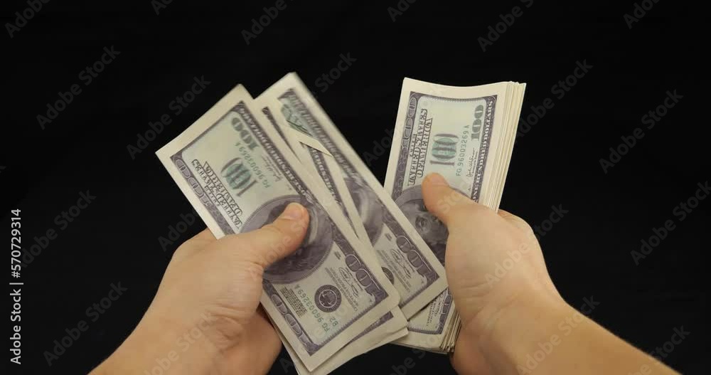 Wideo Stock: Count one hundred 100 dollar bills on a black background with hands. hands are ...