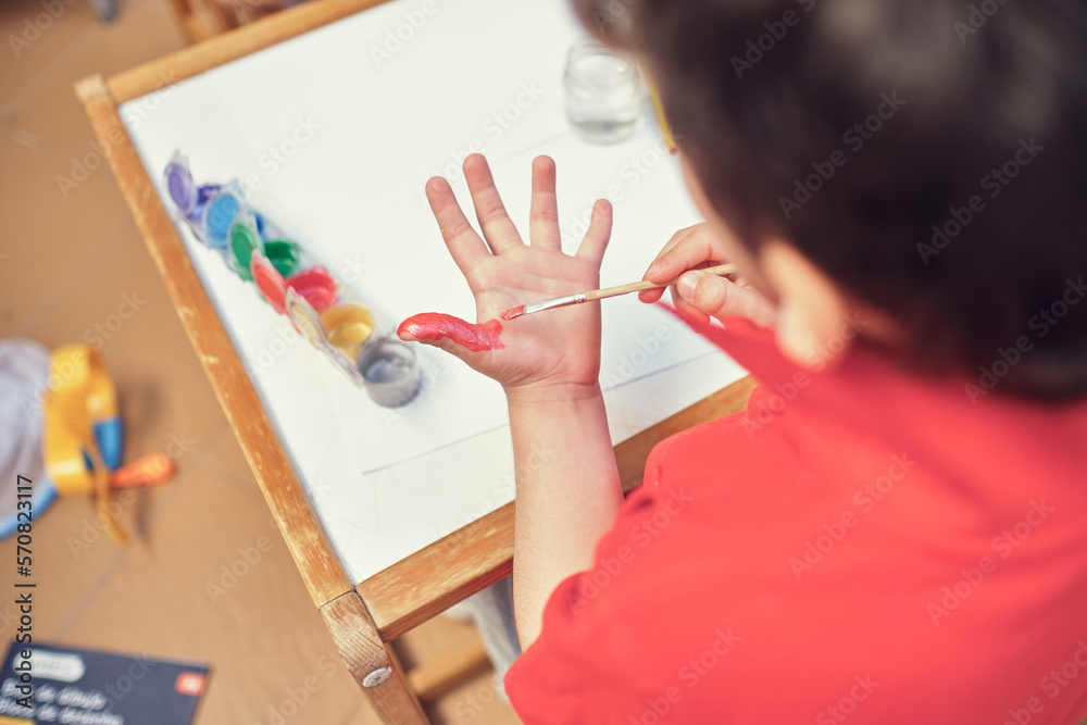 children playing in an inner courtyard and painting with water paints ...