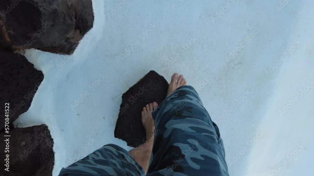 feet of a man walking on a path - white road with black stones on which ...