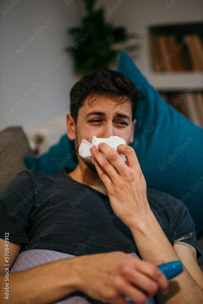 Waist up image of an ill young man coming early from work to home ...