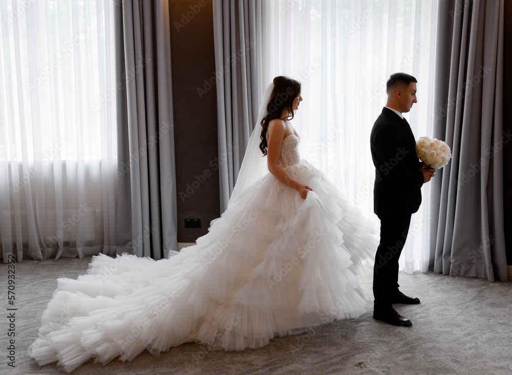 Side view of loving bride couple beautiful woman in ling puffy dress ...