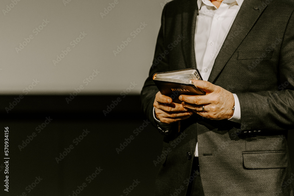 Pastor with a Bible in his hand during a sermon. The preacher delivers ...