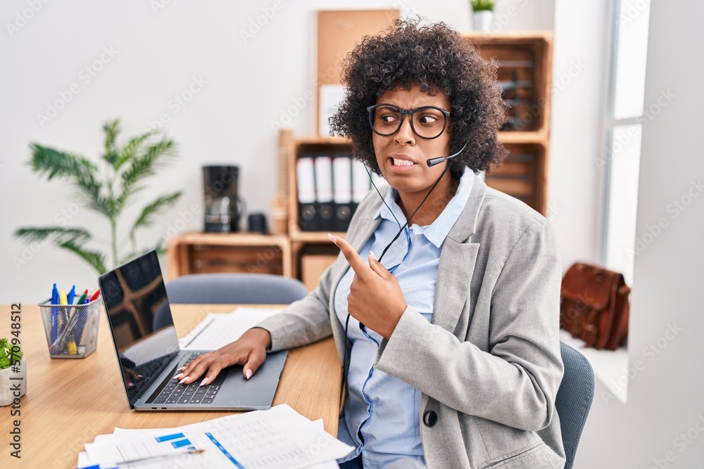 Black woman with curly hair wearing call center agent headset at the ...