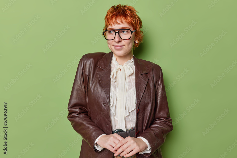Waist up shot of thougthful European woman with stylish haircut smiles ...