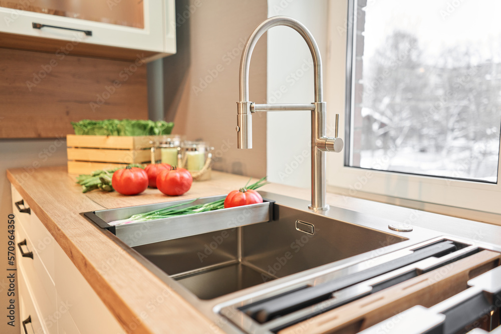 Stylish metallic crane at the kitchen. Sink faucet at the kitchen ...
