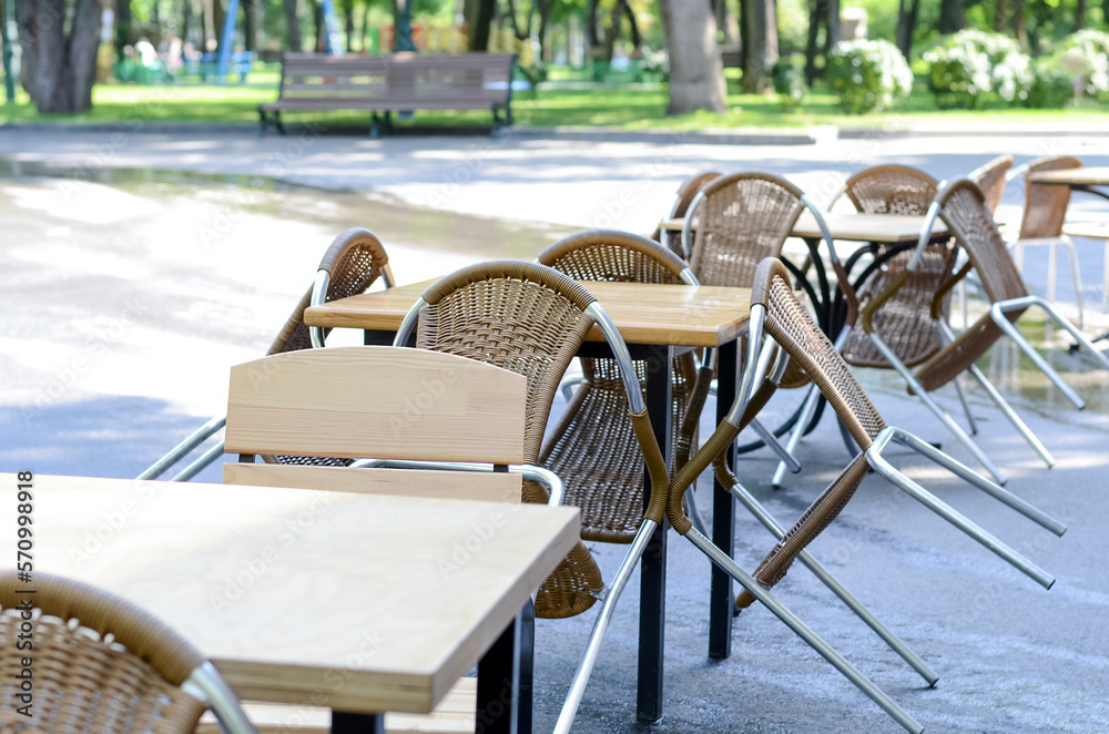 wicker chairs and tables in a cafe or summer restaurant in the park ...