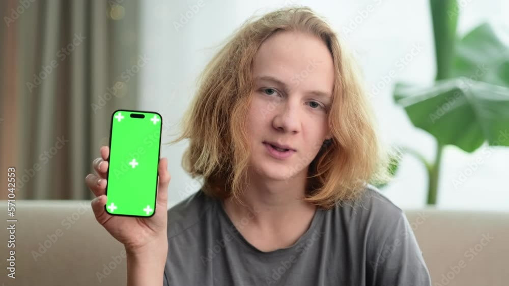 Happy smiling ginger teen boy showing phone with green screen chroma ...