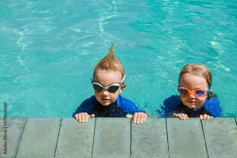 Happy children in wetsuits and goggles learn to swim, have fun at ...