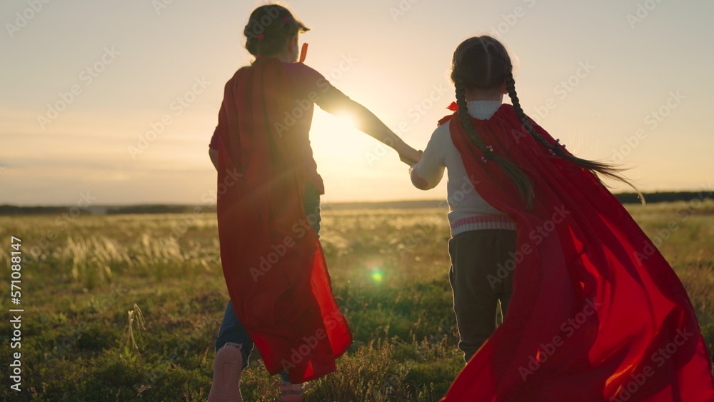 Childrens games and dreams. Happy girls play superheroes they run ...