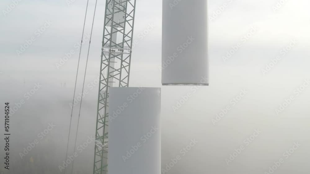 Lattice boom crawler crane hoisting a wind turbine tower under ...