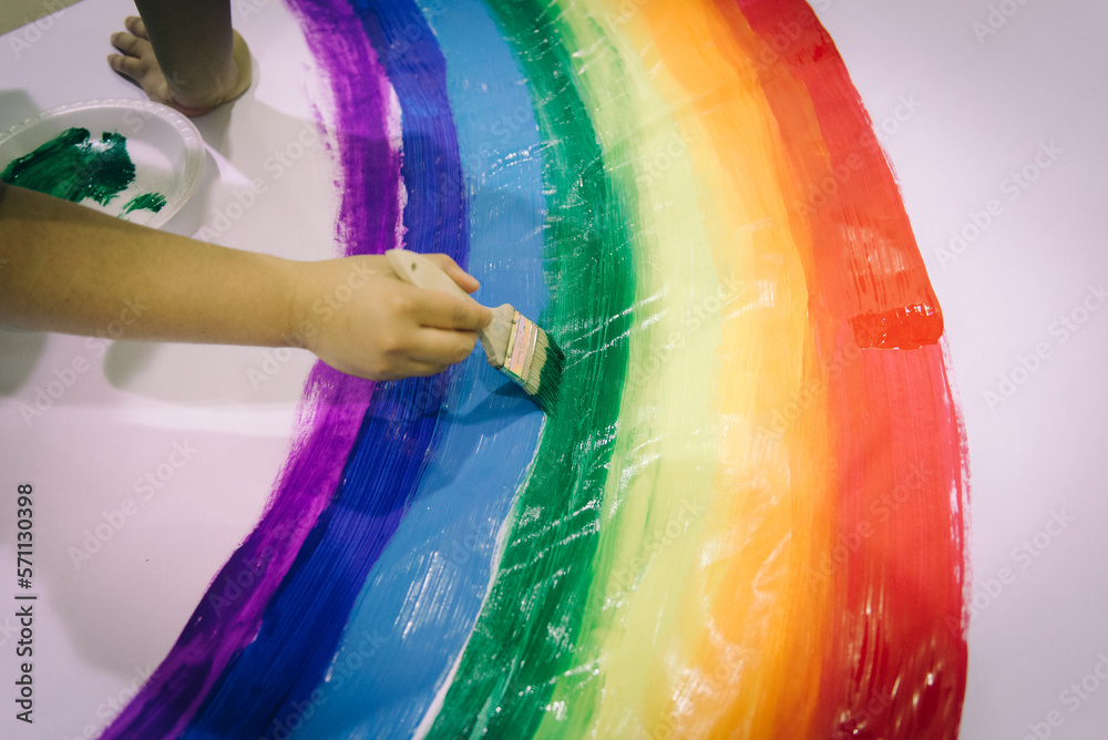 Person painting large rainbow with a paint brush Stock Photo | Adobe Stock