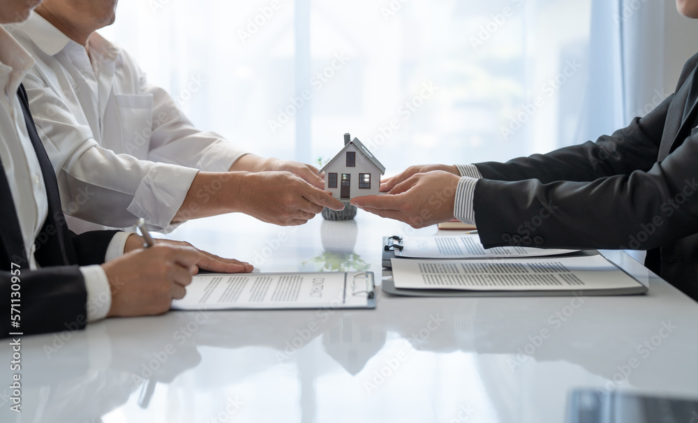 Young Asian real estate agent, and insurance salesman handing over a ...