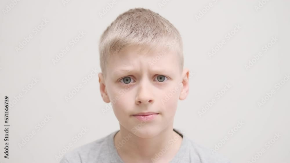 Frowning caucasian boy looking angry at camera. Upset male child ...