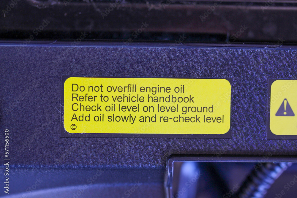 Engine oil warning sticker in the engine bay of a new car Stock Photo ...
