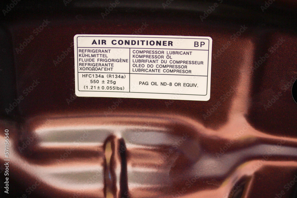 Air conditioner warning label in the engine compartment of a new car ...