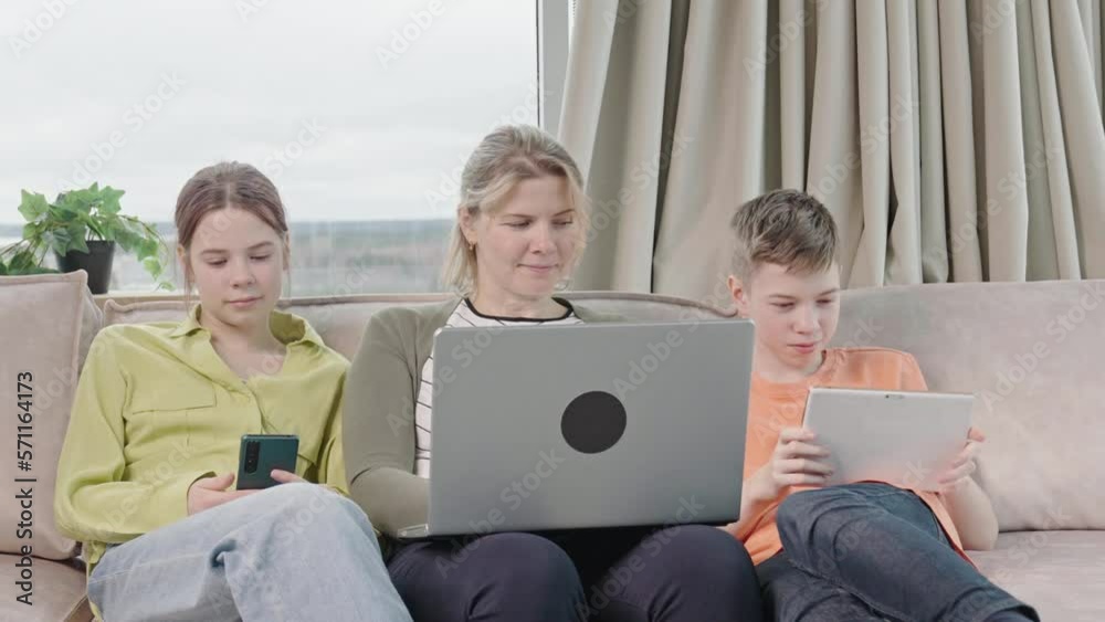 Happy family with kids sit on sofa in living room have fun using laptop ...