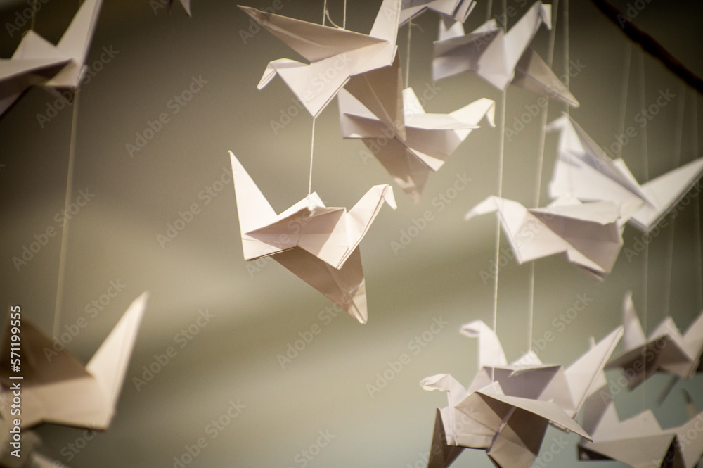Japanese folded Origami cranes hanging on with strings. Hundreds ...