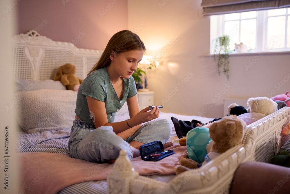 Young Diabetic Girl Sitting On Bed In Bedroom At Home Using Kit To ...