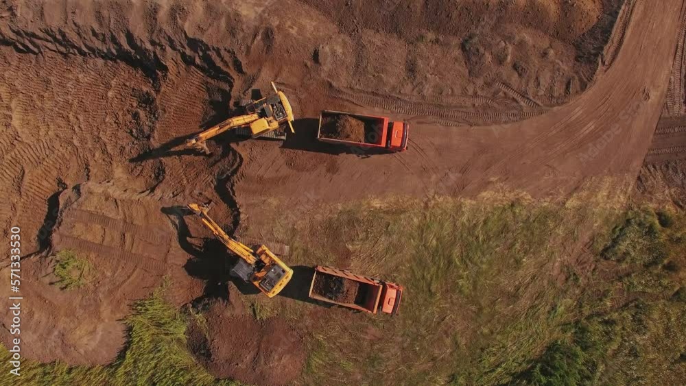 Excavator loading dumper trucks. Earthmoving at construction site ...