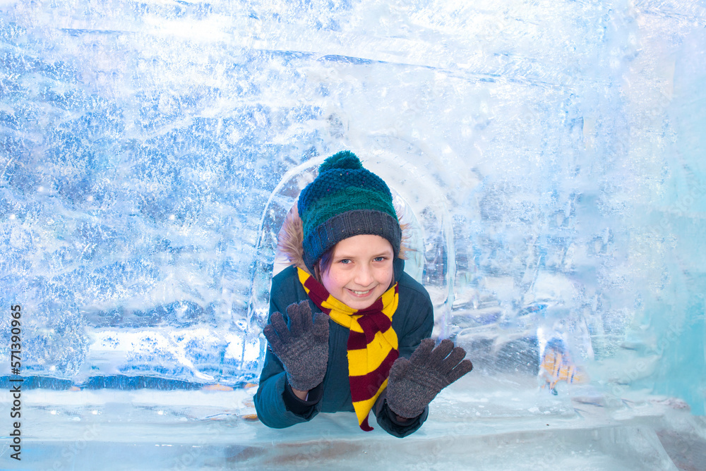 happy boy looks out of the window of the ice house. joyful child ...