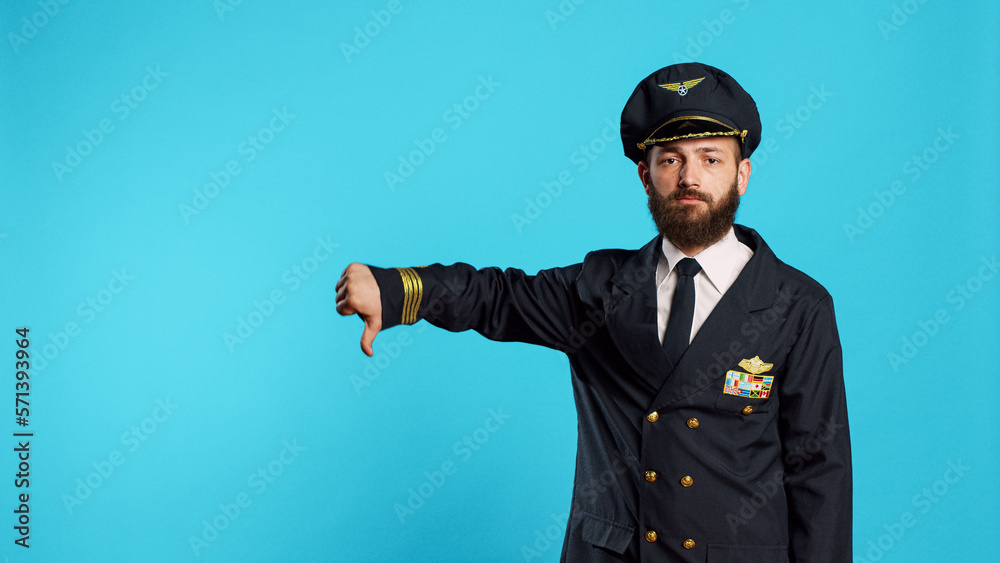 Professional aviator showing thumbs down sign, expressing dislike and ...
