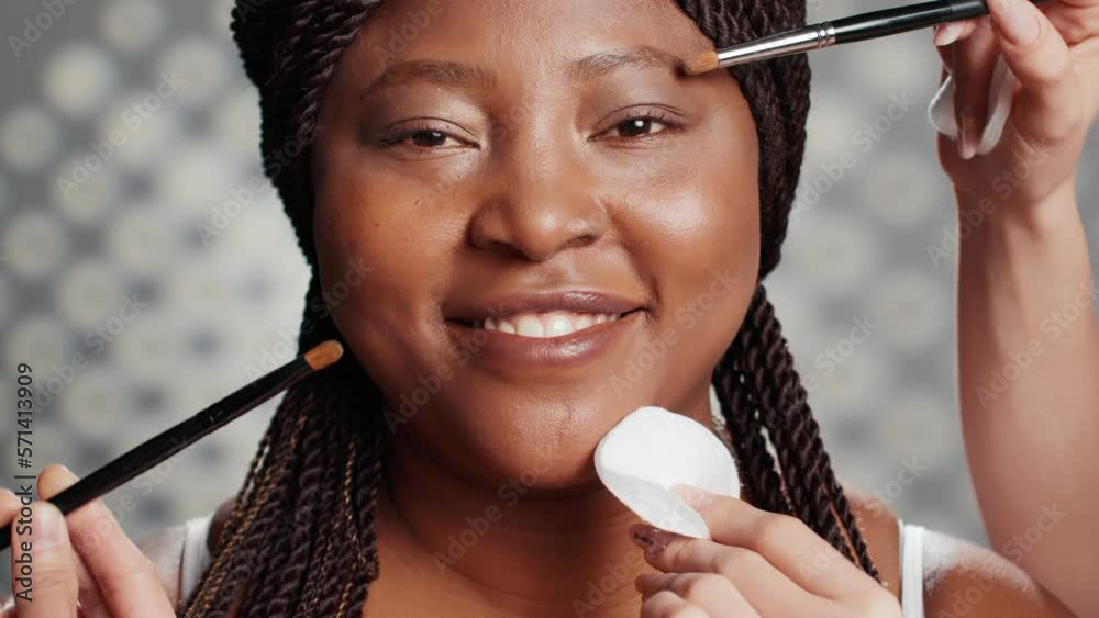 African american woman receiving makeover from team of make up artists ...