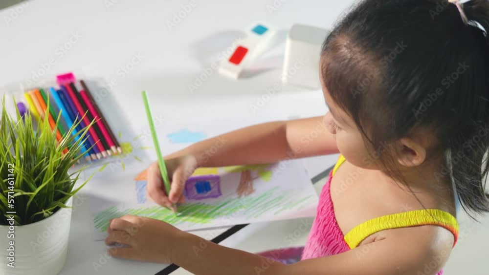 Asian cute kid preschooler sit on table smile she draw country house ...