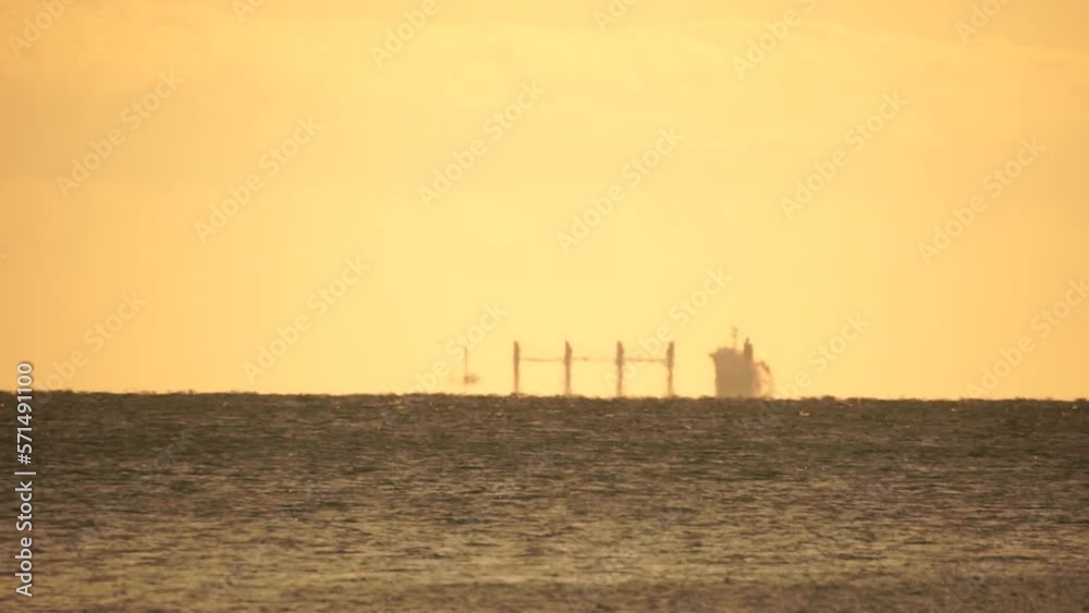 Mirage of cargo ship in the sea beyond the horizon. Ship sailing in the ...