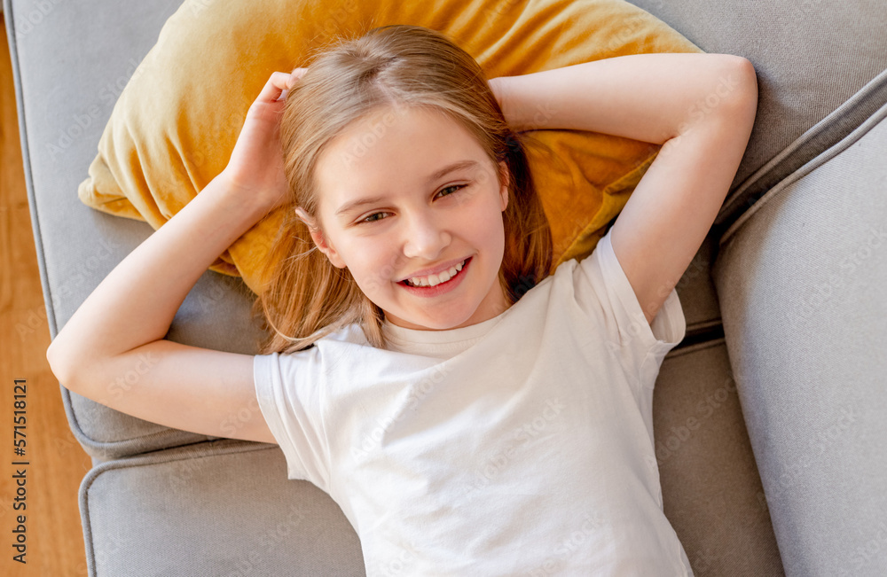 Preteen girl lying on sofa and posing Stock Photo | Adobe Stock