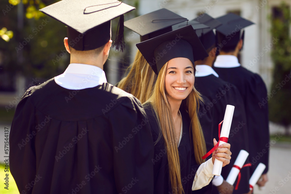 Graduation.Young happy woman graduate looking back at camera during ...