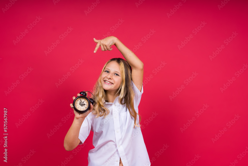 Teen girl 12, 13, 14 years old look at alarm clock. Good morning ...