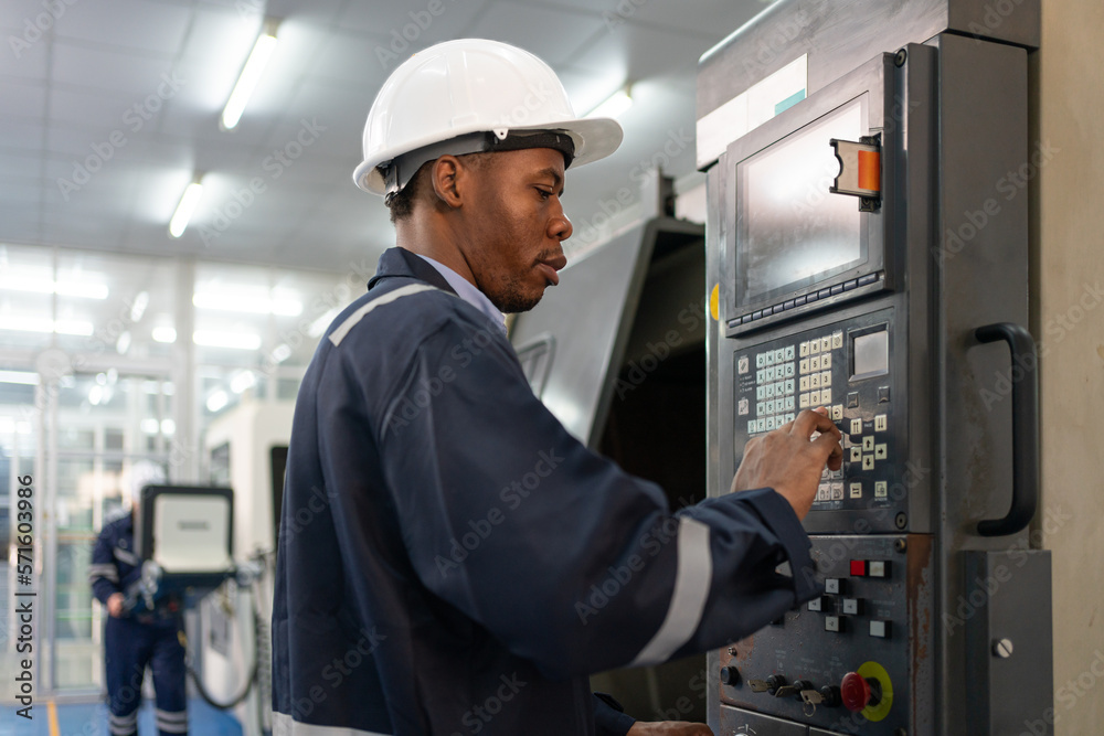 Male engineer operating cnc machine in control panel at factory. Man ...