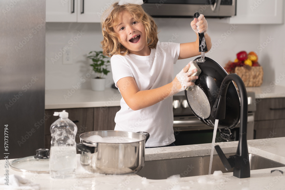Child help in washing dishes at kitchen. Clean washed dishes ...