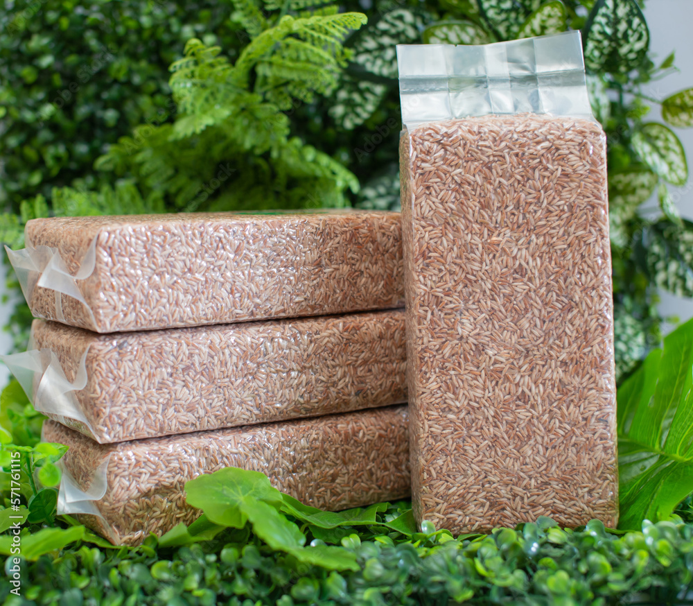 Rice grains are vacuum packed in plastic bags. isolated on a green ...