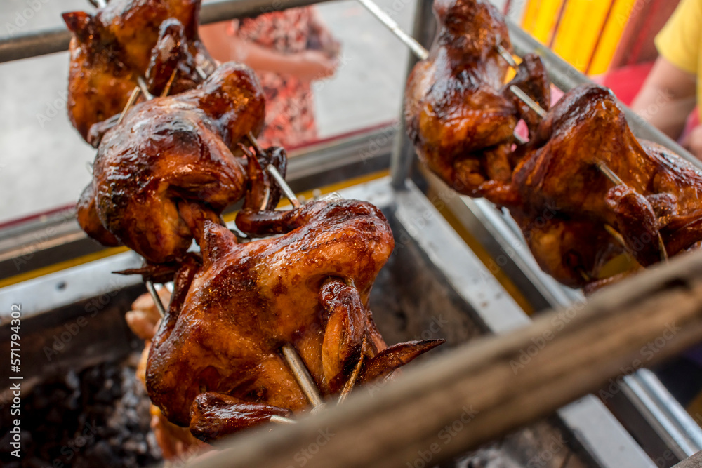 Lechon manok, a Filipino spit-roasted chicken dish. As seen being ...