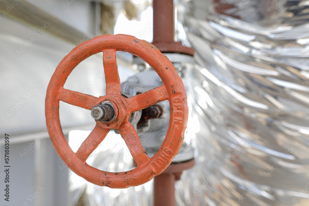 Shallow depth of field details with a metallic pipe valve used to open ...