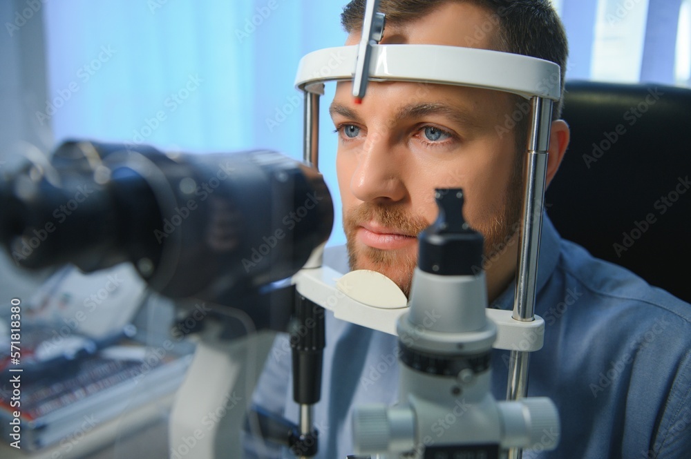 Handsome young man is checking the eye vision in modern ophthalmology ...