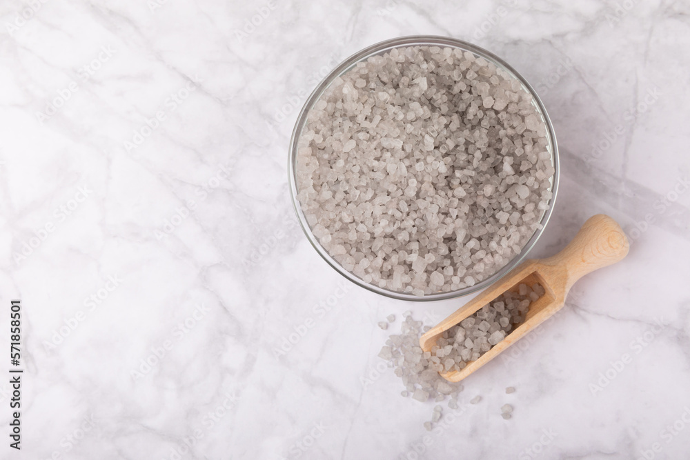 Sea salt in a bowl on a white marble background. Spice. Bath salt. Spa procedures. Skin care ...