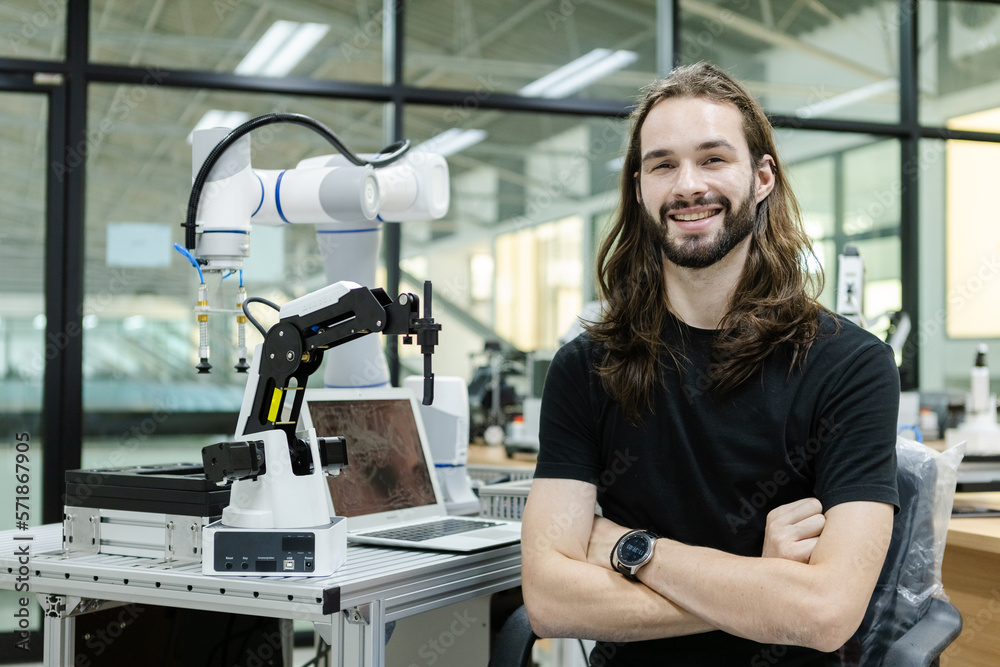 Male staff engineer sitting crossed arms with robot for education ...