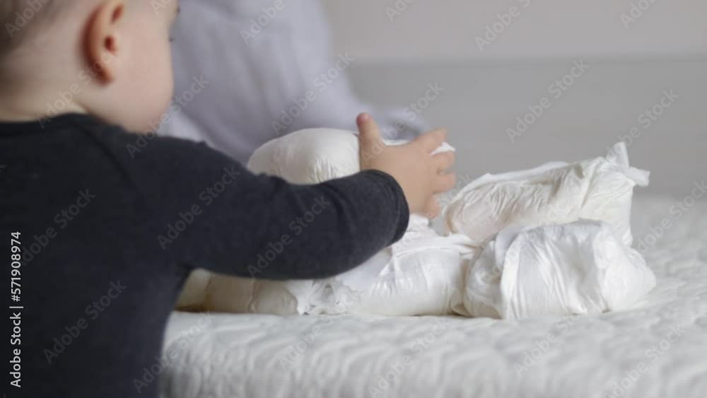 many dirty full baby diapers on floor bed or in blue trash plastic bag ...