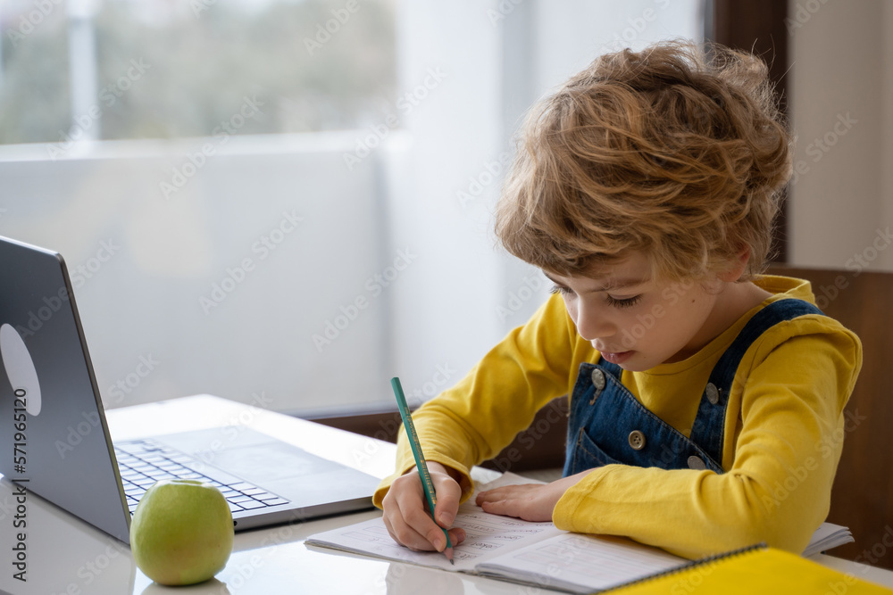 Caucasian child schoolboy or girl studying at home using laptop remote ...