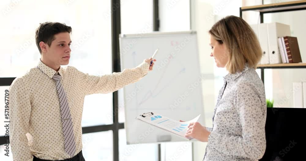 Female boss listens to student intern report on growth of company ...