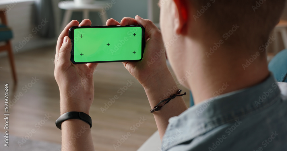 Man using a smart phone with mock up green screen, talking while having ...