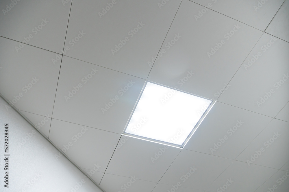 Square lamp on a white office ceiling. Interior design in the office. A ...