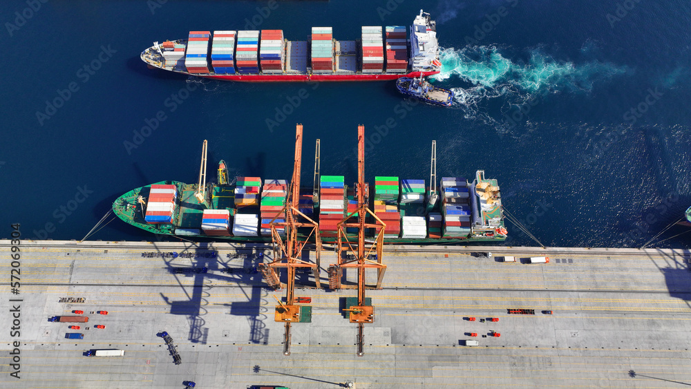 Aerial drone top down photo of container ship guided by tug boat to ...