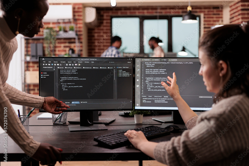 Multi ethnic tech enginners developing html code and cloud computing in ...