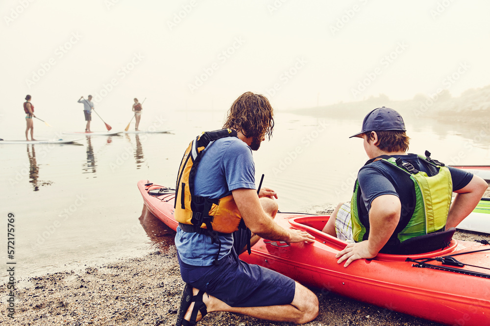 Instructor helps his young student get ready for a kayaking trip Stock ...