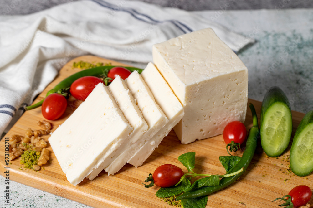 Ripe white cheese. Feta cheese made from cow's milk on a wooden serving ...
