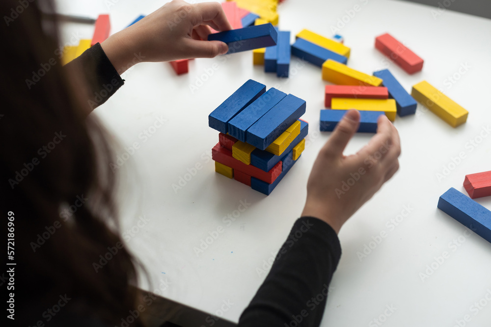 Children building wood blocks at playground. Girl kid playing stacking ...