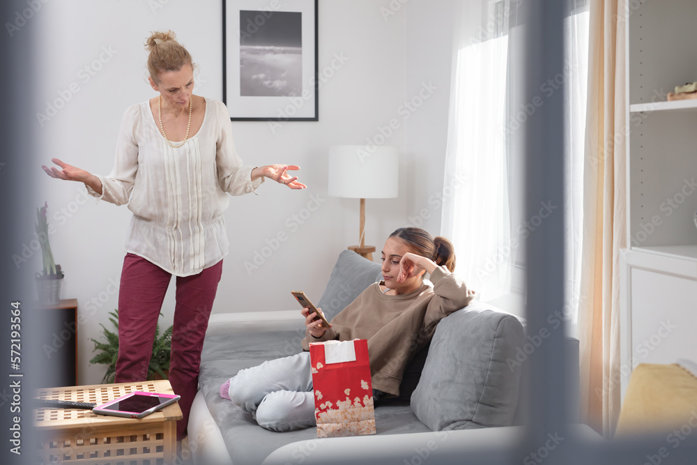 Mother having trouble with a lazy teenager girl at home while playing ...